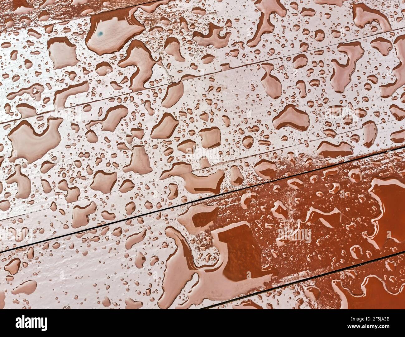 Rain water drops on red wooden diagonal texture furniture in outdoors ...