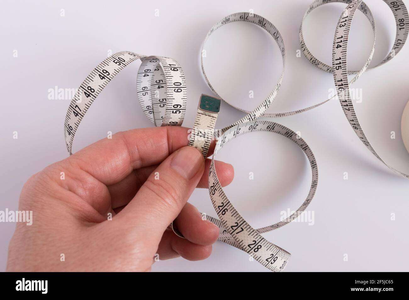 Woman hand holding a flexible tailor sewing meter Stock Photo - Alamy