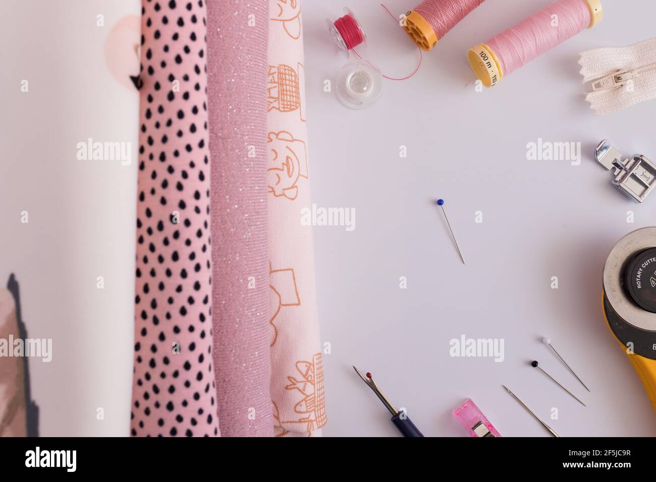 Stacked folded fabrics next to some tailor useful accessories on a ...