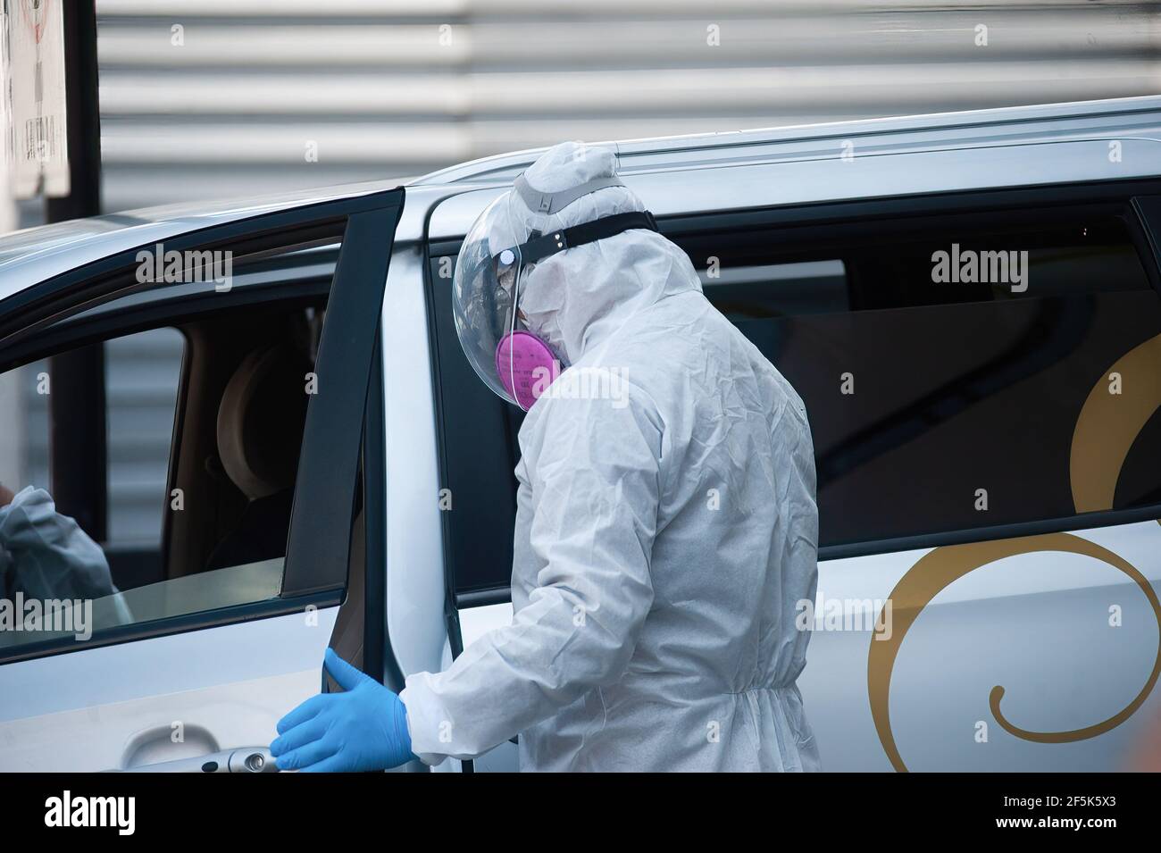 A funeral home staff seen wearing a Personal Protective Equipment suit ...