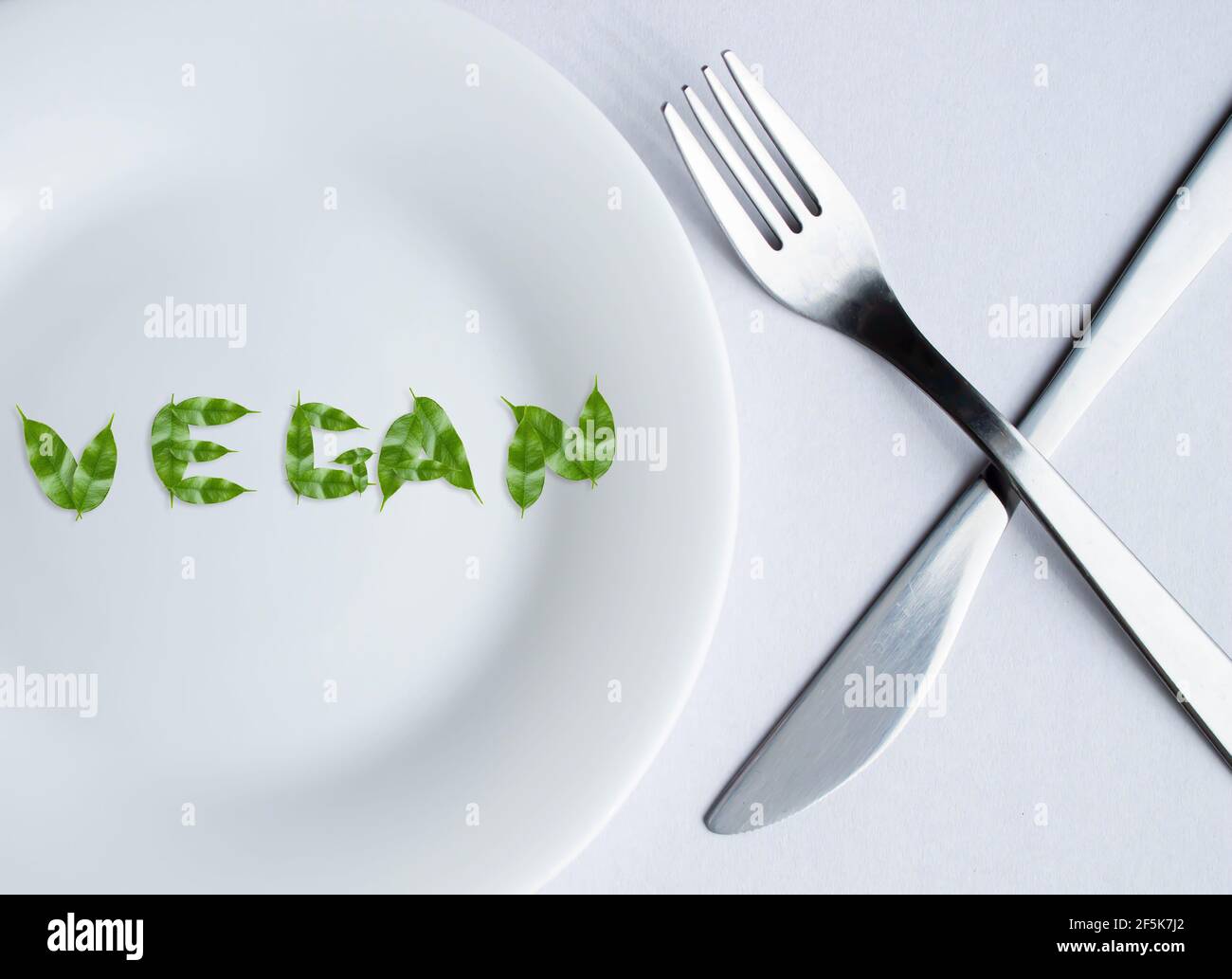 Vegan lettering made from leaves on a plate. The letters are composed ...