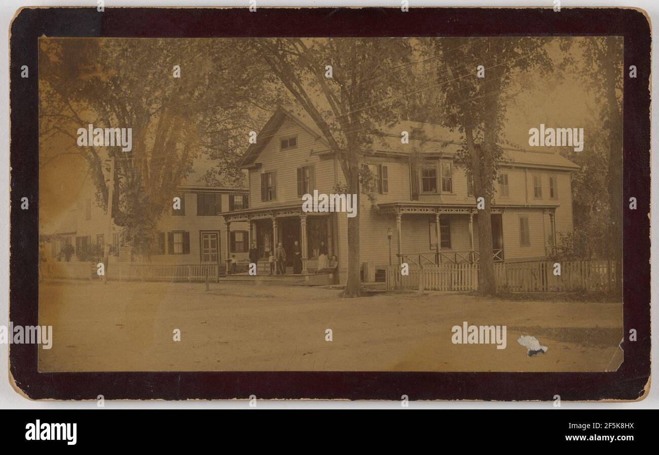 Long view of house with family on front porch. Know (American, active ...