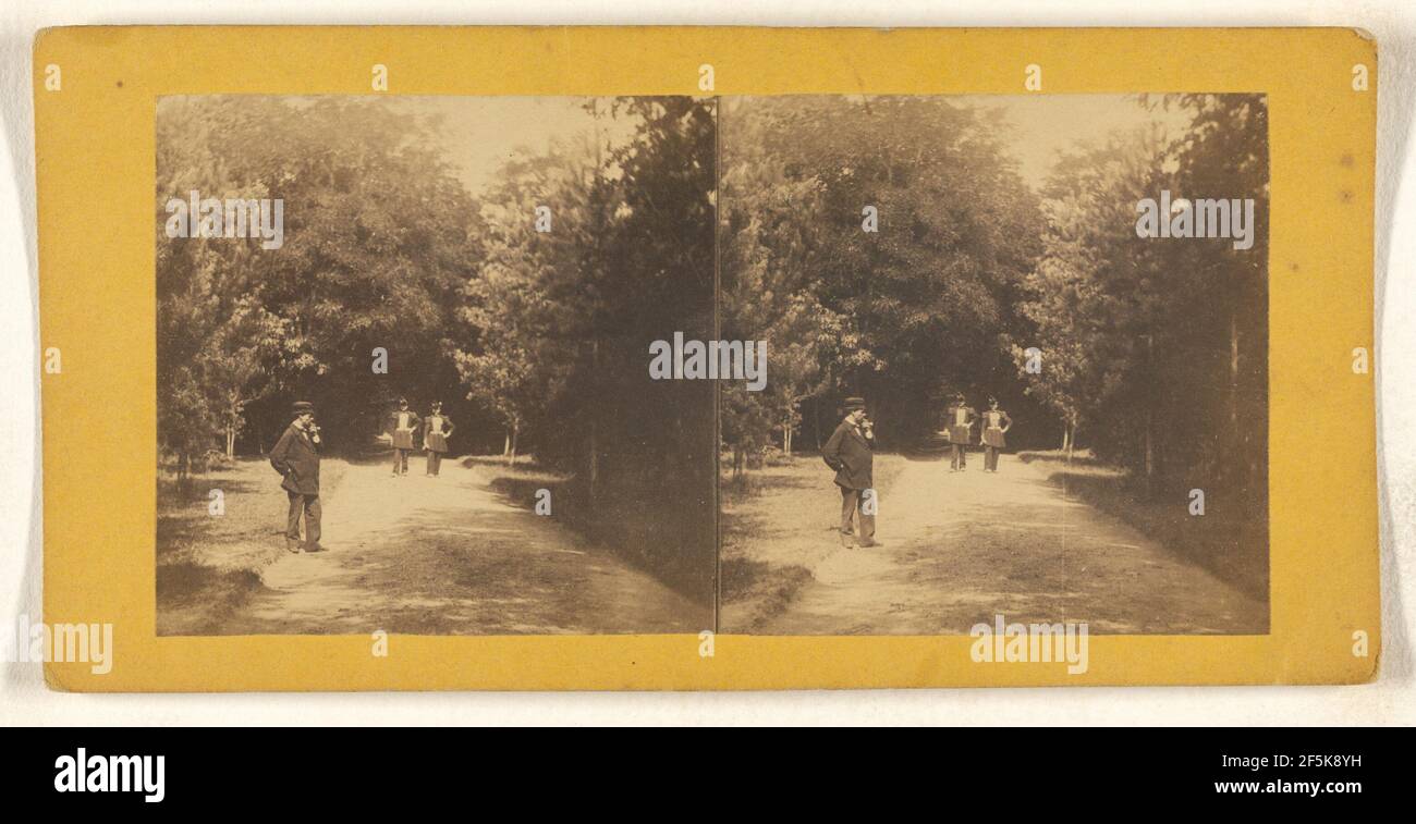 Two men in military garb walking down a path, another man standing to ...