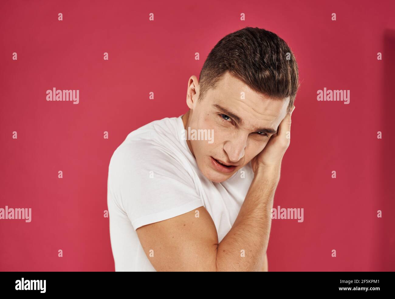 emotional man white t-shirt cropped view discontent red background ...