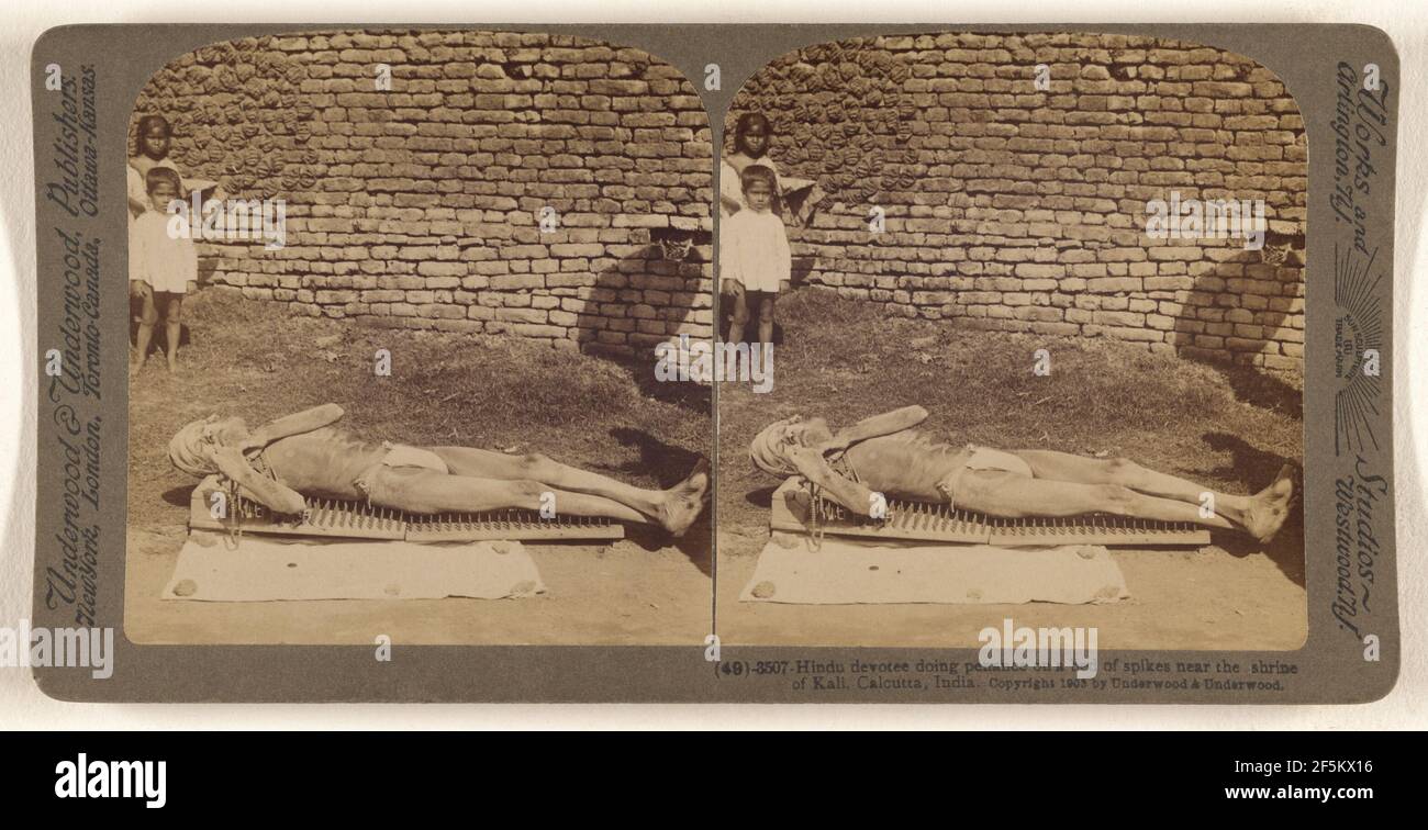 Hindu devotee doing penance on a bed of spikes near the shrine of Kali ...