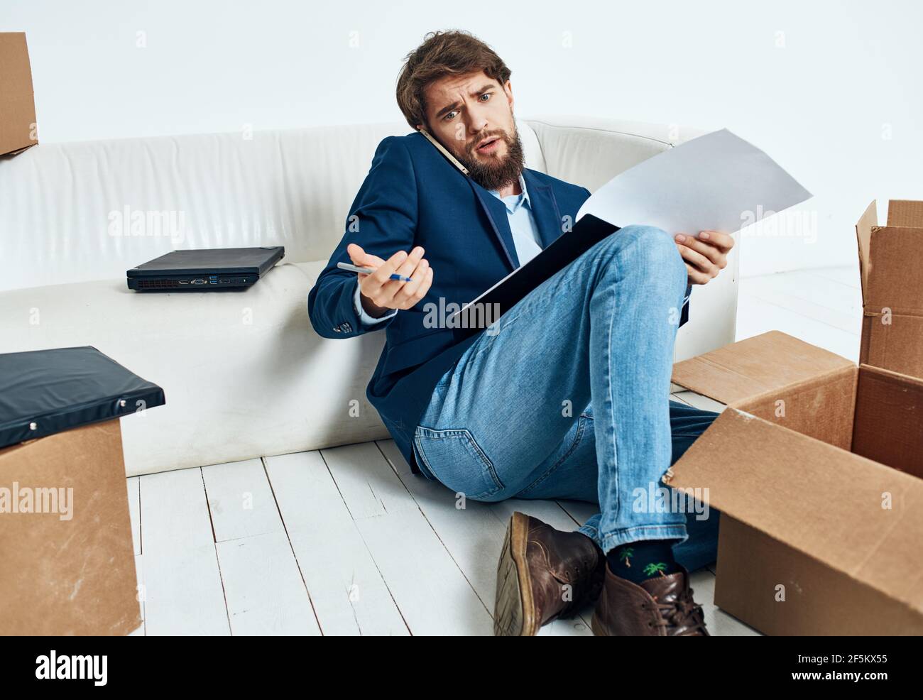 Business man near boxes with things unpacking moving to a new location ...