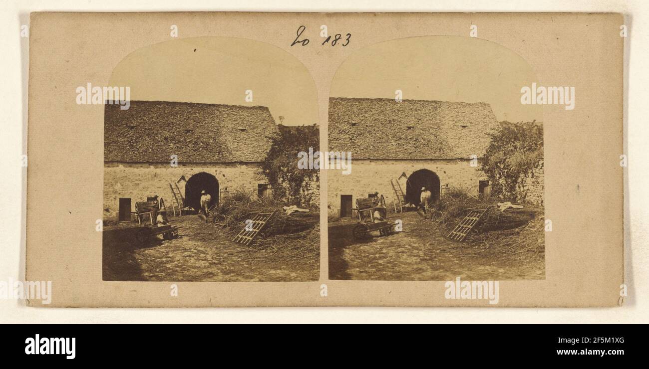 View of barnyard and barn, man standing in archway of barn. Attributed ...