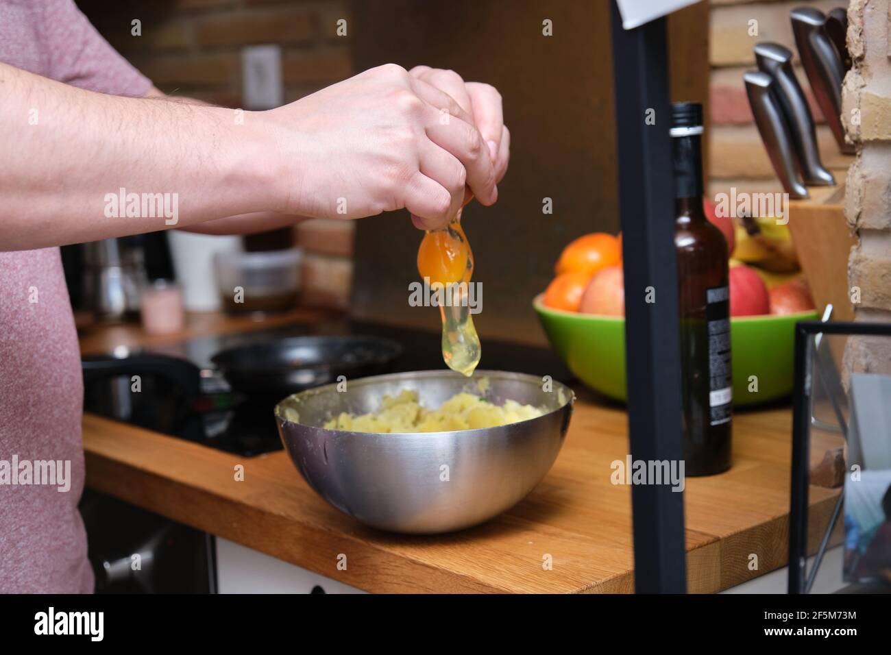 Unrecognizable young man cracking or breaking an egg on a bowl. Cooking ...