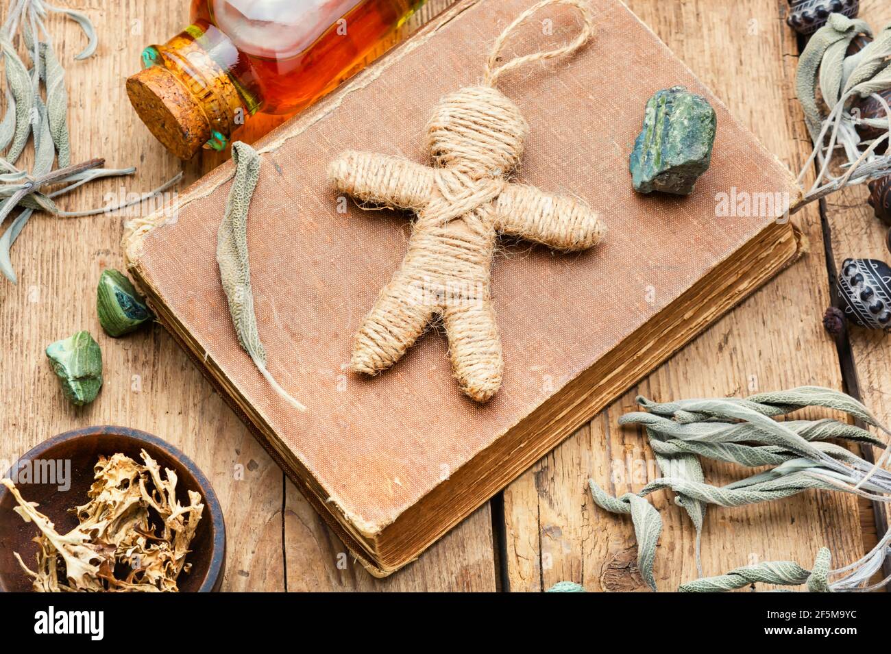 Voodoo doll,magical herbs and witchcraft attributes on an old table ...