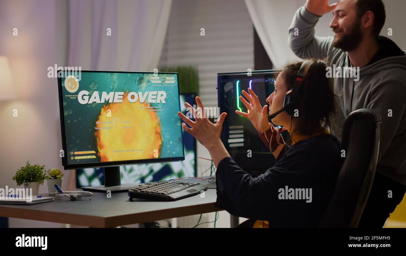 Stressed couple gamers losing space shooter video game playing on RGB ...