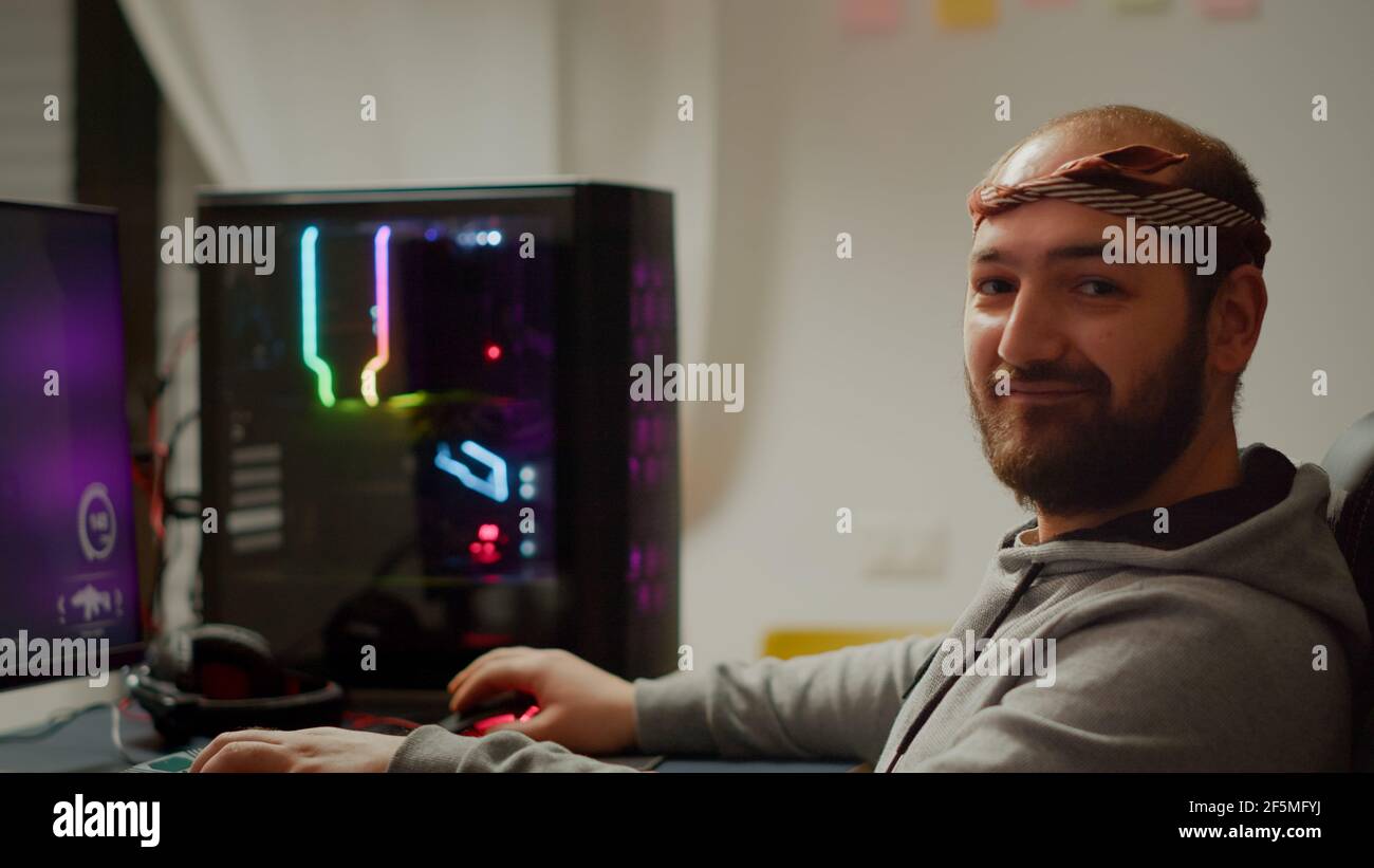 Portrait of young pro gamer man sitting at powerful personal computer ...