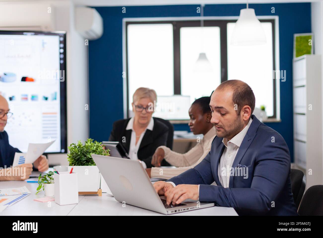 Busy business man using laptop typing sitting at conference table in ...