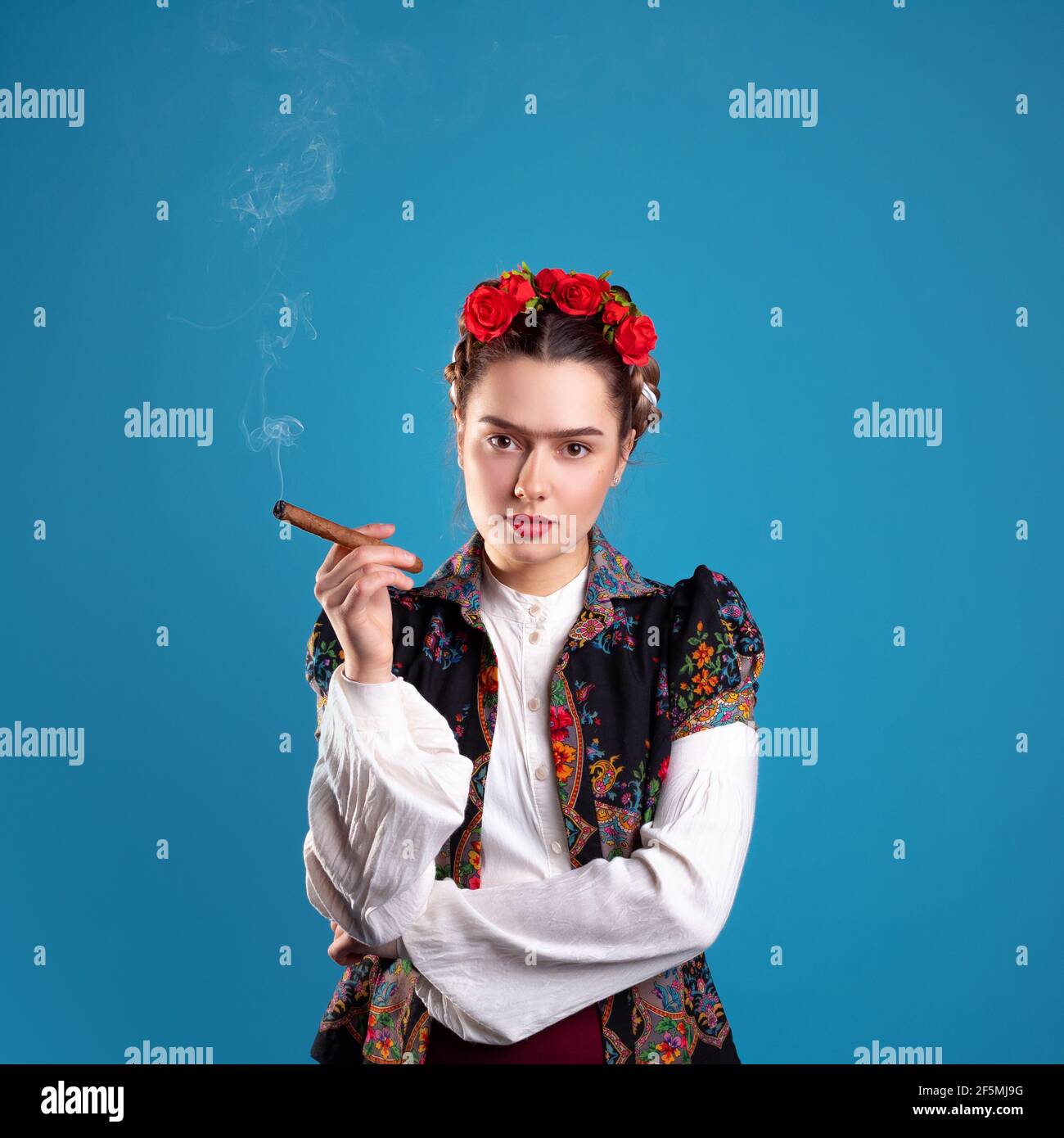 Young woman in the image of the Mexican artist Frida with red roses in ...