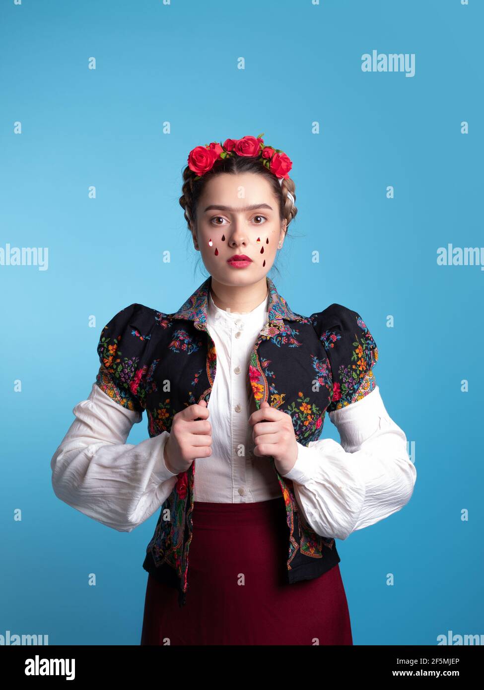 Young woman in the image of the Mexican artist Frida with red roses in ...
