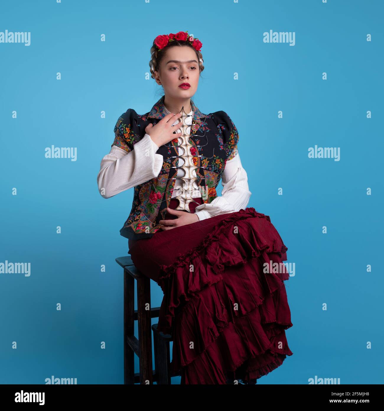 Young woman in the image of the Mexican artist Frida holds its symbolic ...