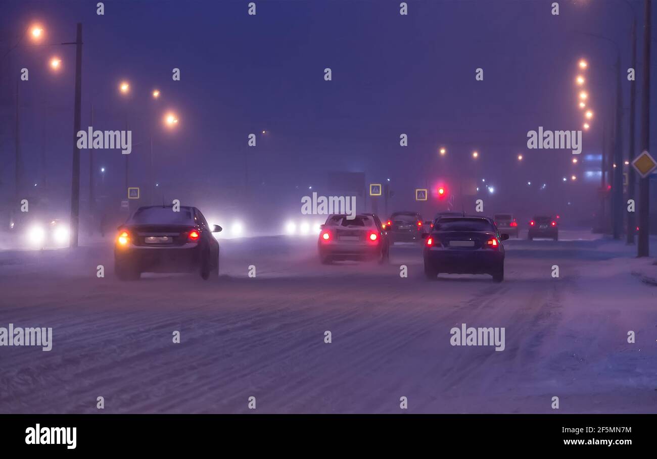 Cars drive along snow-covered road at night in winter Stock Photo - Alamy