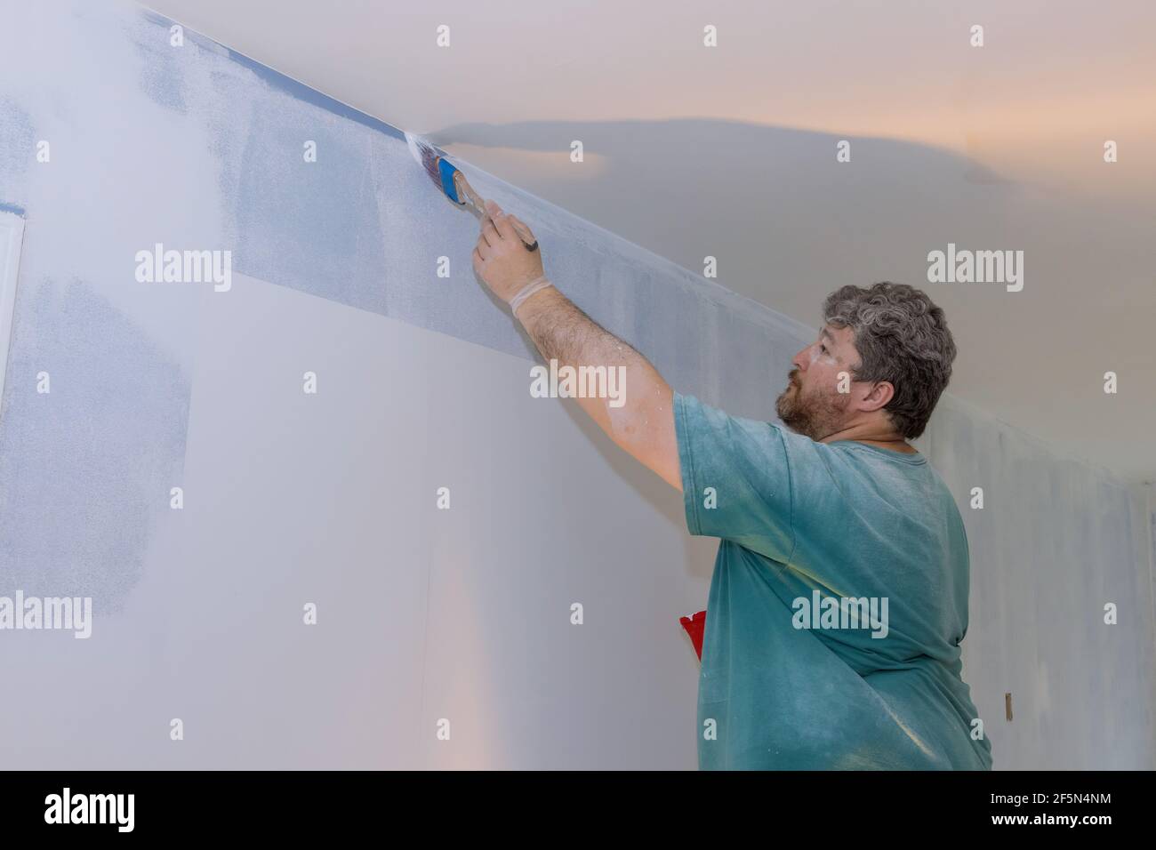 Professional painter using a brush to applying paint on wall Stock ...