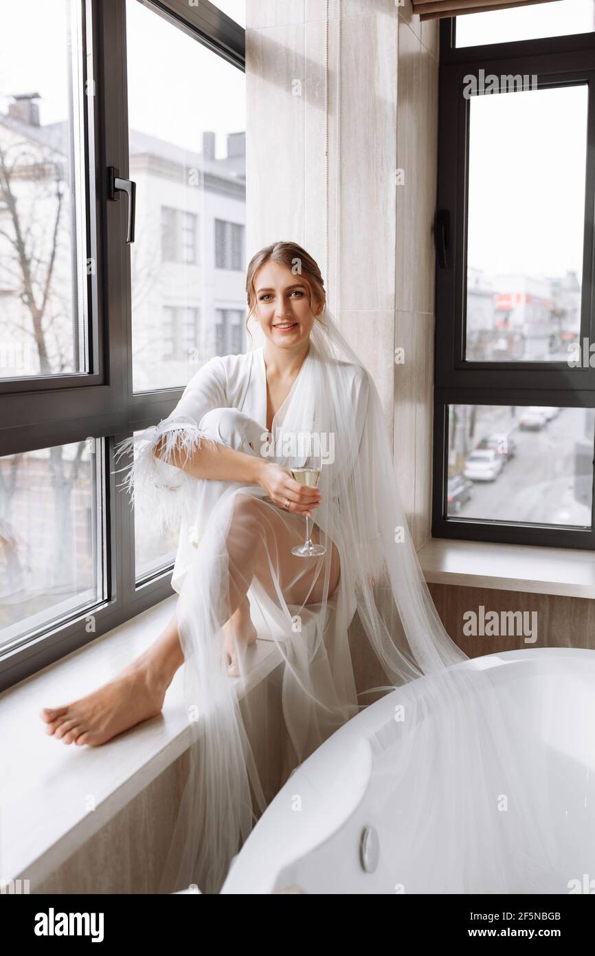 Bride s morning. Bride drinking champagne in the peignoir. young woman ...