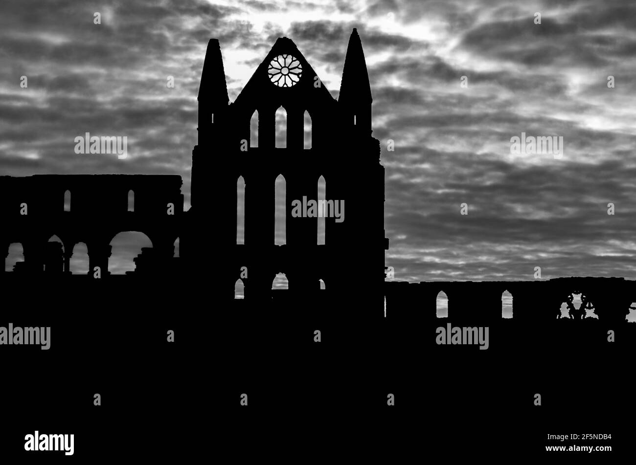 Whitby Abbey, North Yorkshire, UK in silhouette against a cloudy winter ...
