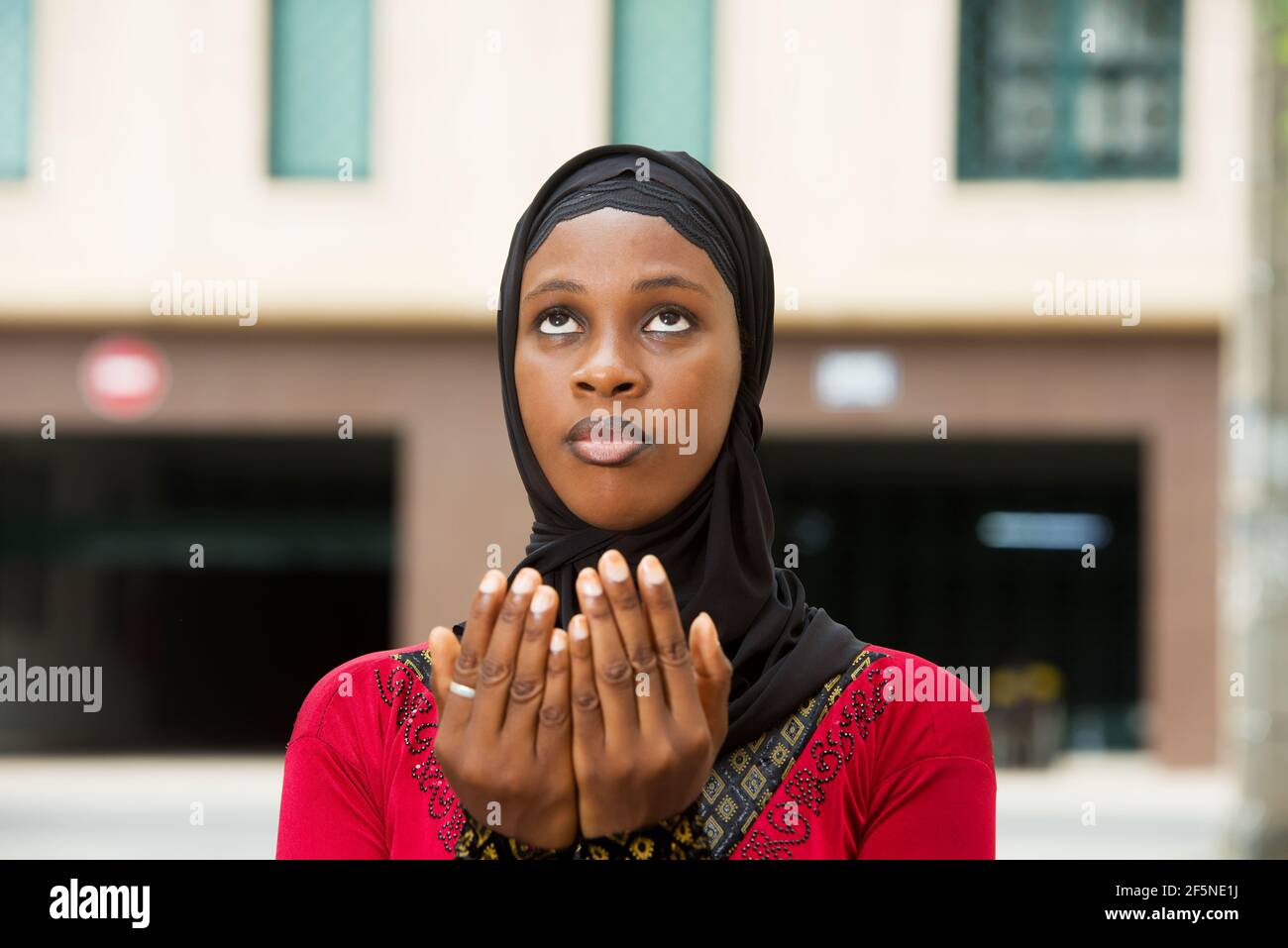 young muslim woman standing outdoors praying Stock Photo - Alamy