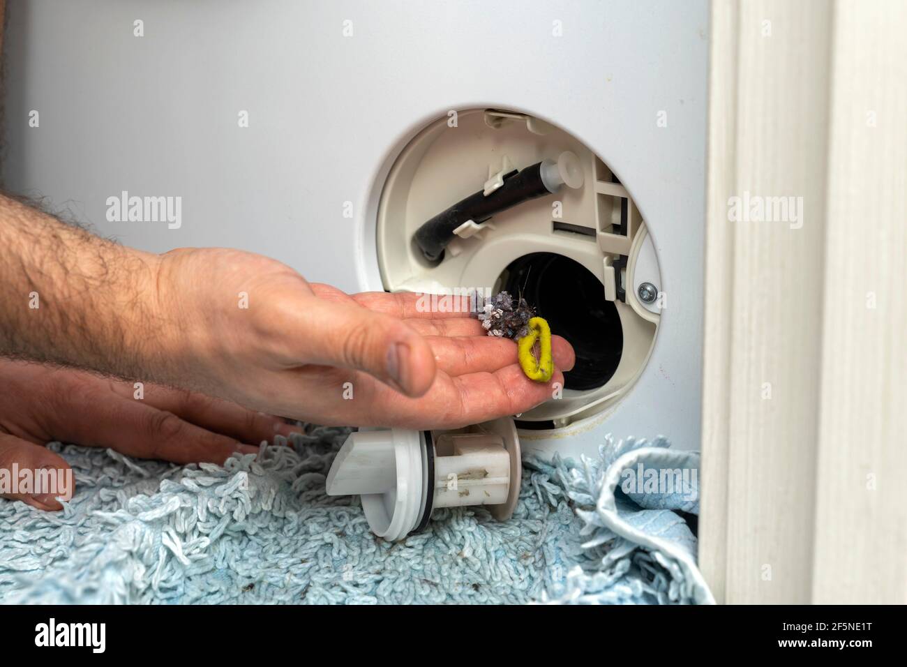 the master takes out the dirt from the filter of the washing machine ...