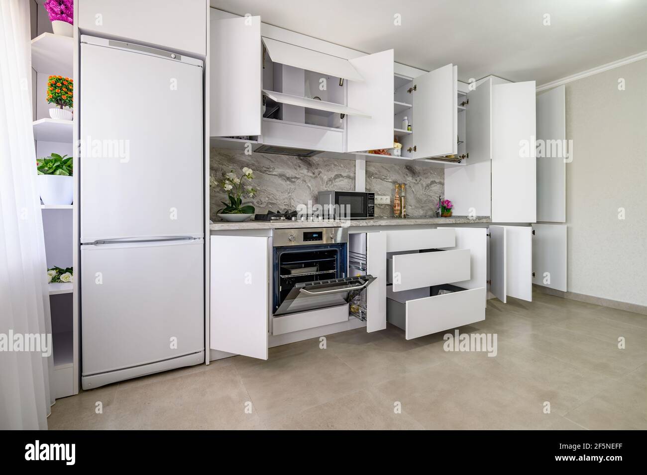 White modern kitchen interior, some drawers pulled out Stock Photo - Alamy