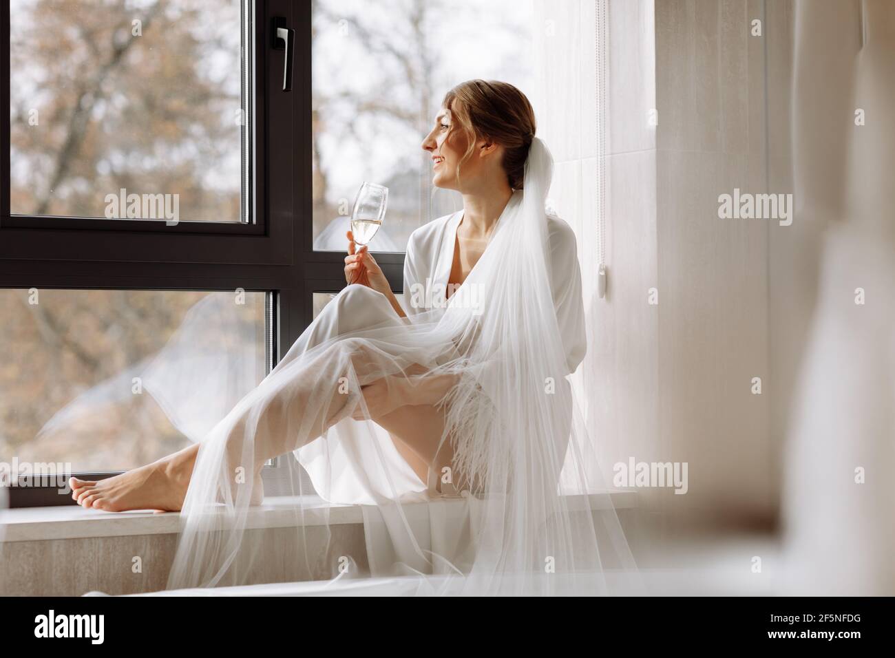 Bride s morning. Bride drinking champagne in the peignoir. young woman ...