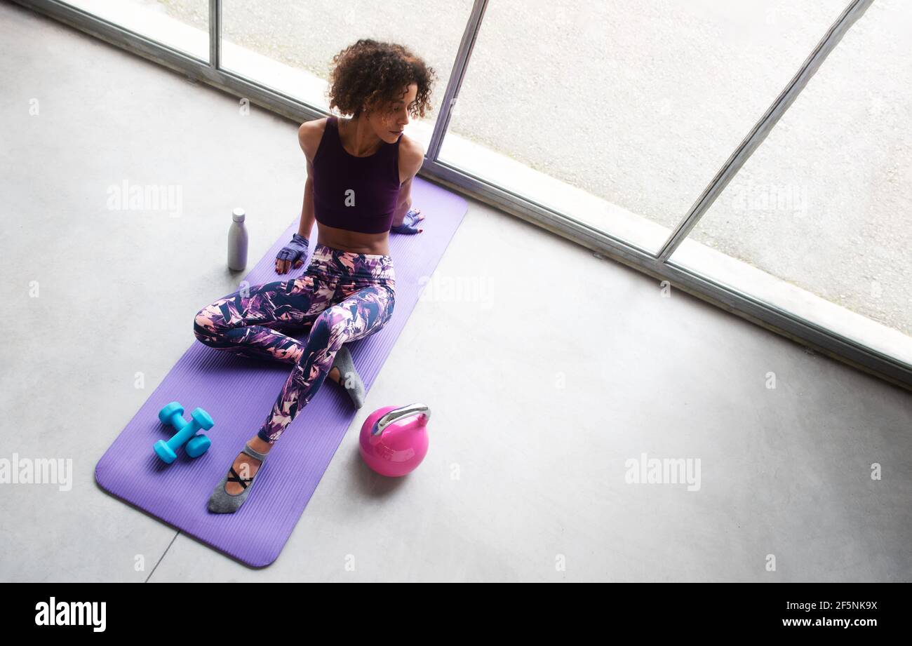 View from the top of a Young Woman doing workout on a mat on the floor ...