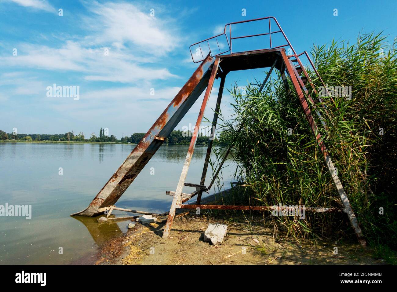 Old abandoned and rusty slide on the pond shore Stock Photo - Alamy