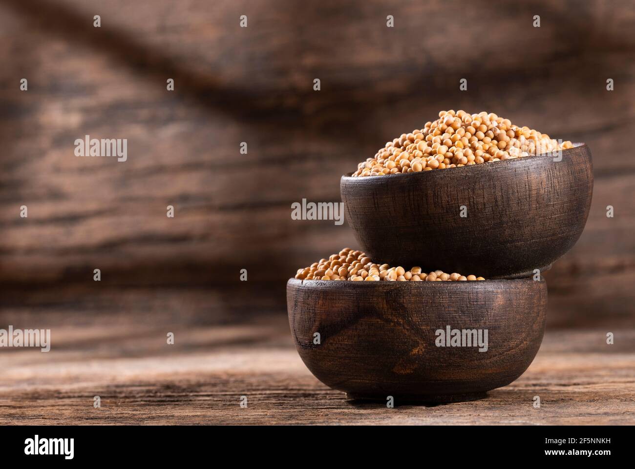 Organic yellow mustard seeds in wooden bowls - Sinapis alba Stock Photo ...