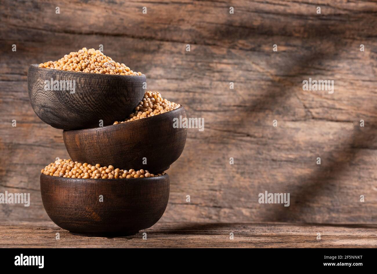 Sinapis alba - Organic yellow mustard seeds in wooden bowls Stock Photo ...