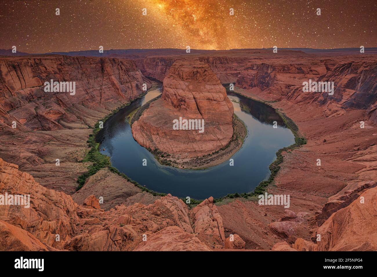 Aerial shot of the Horseshoe Bend in Arizona under an orange starry ...