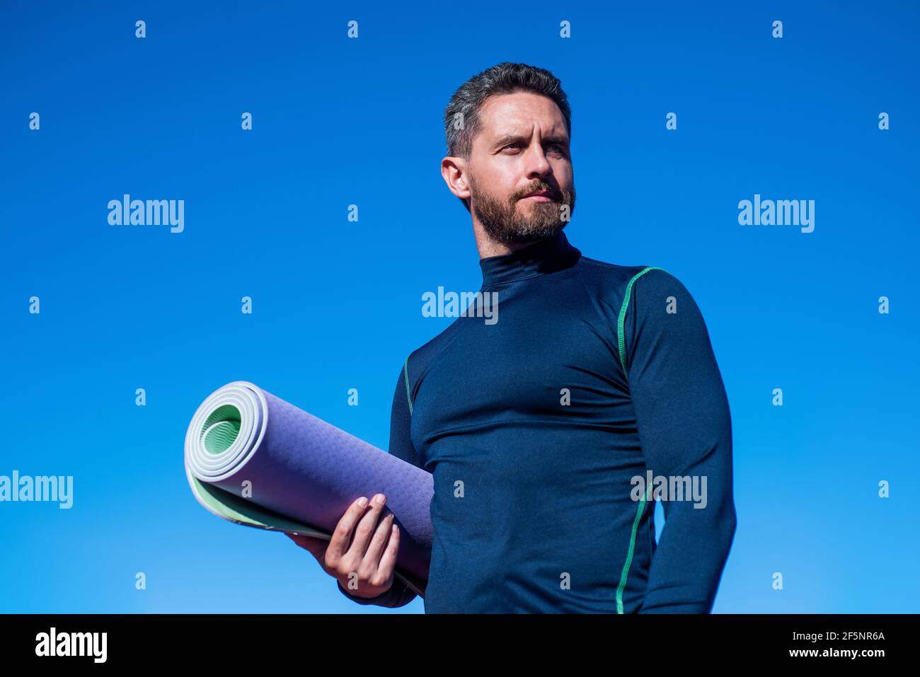 athletic muscular man hold yoga mat, pilates Stock Photo - Alamy