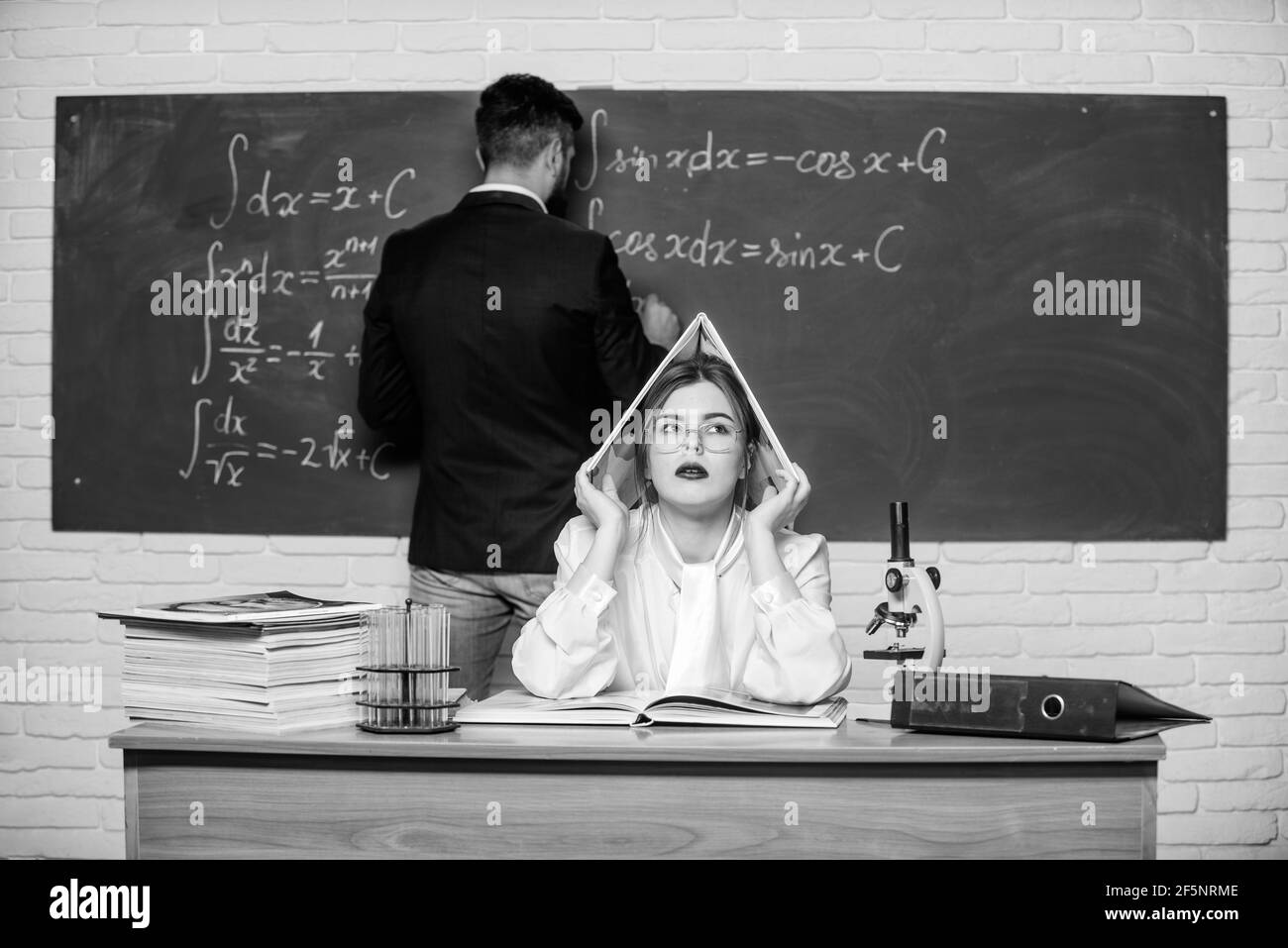Solving task. Man writing on chalkboard math formulas. Teaching in ...