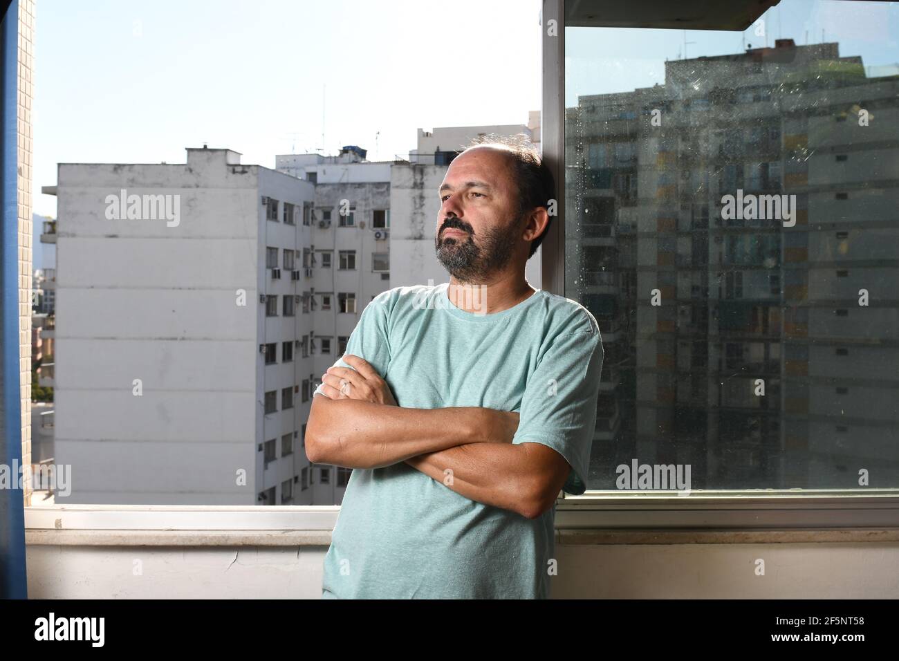 man leaning by the window with thoughtful expression Stock Photo - Alamy