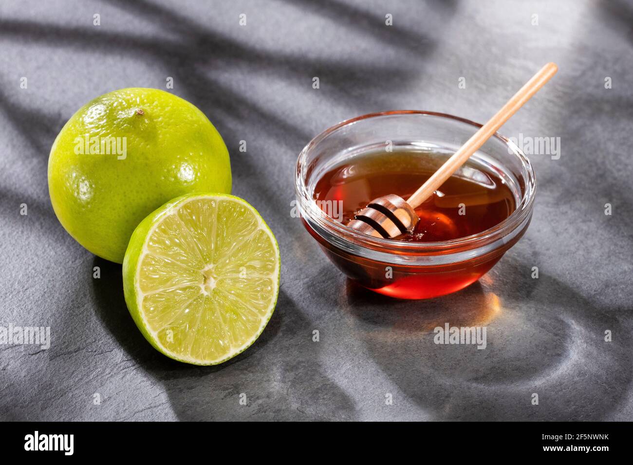 Honey in a glass bowl and lemon on the table Stock Photo - Alamy