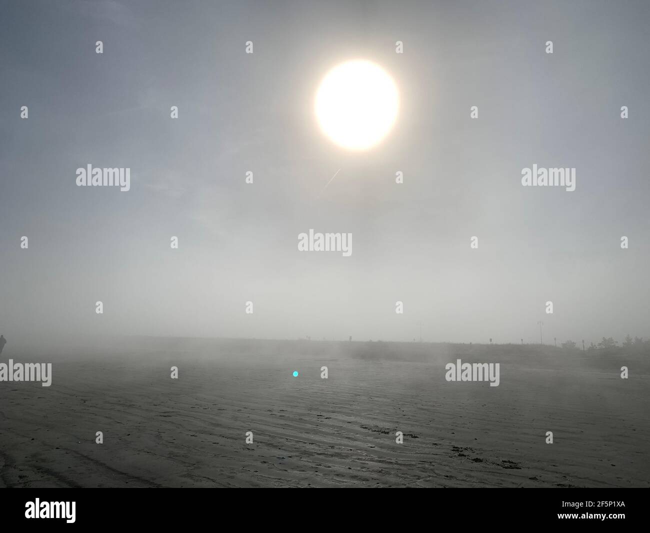 View of the sun through the fog on the beach Stock Photo - Alamy