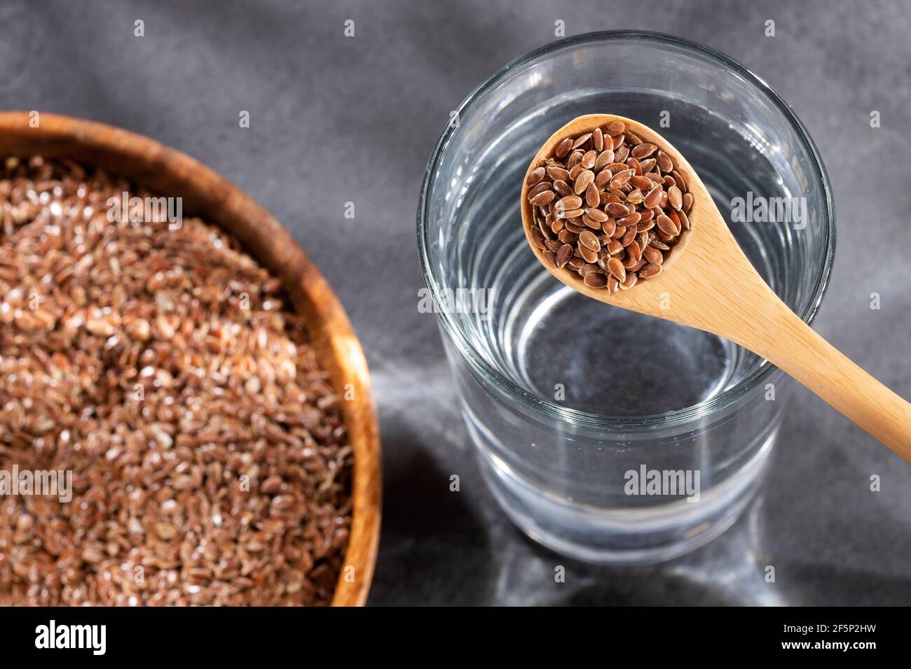 Linum usitatissimum - Spoon with organic flaxseeds and glass of ...