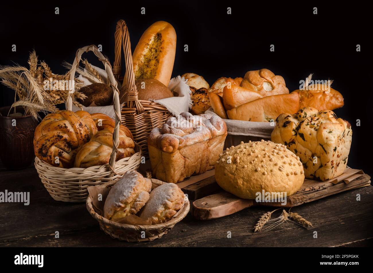 Still life of a varied assortment of breads on a black background ...