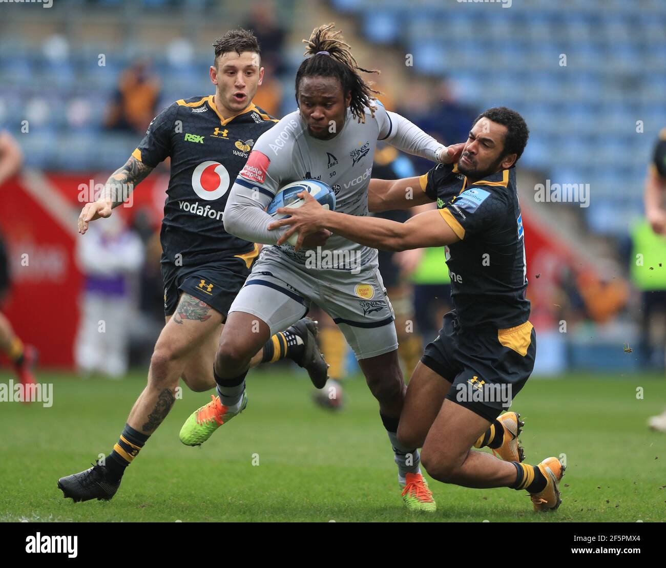 Sale Sharks' Marland Yarde (centre) holds off Wasps' Zach Kibirige ...