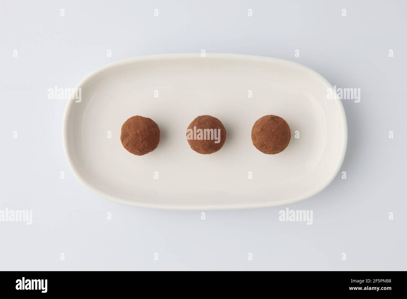 chocolate truffles on plate on white background Stock Photo - Alamy