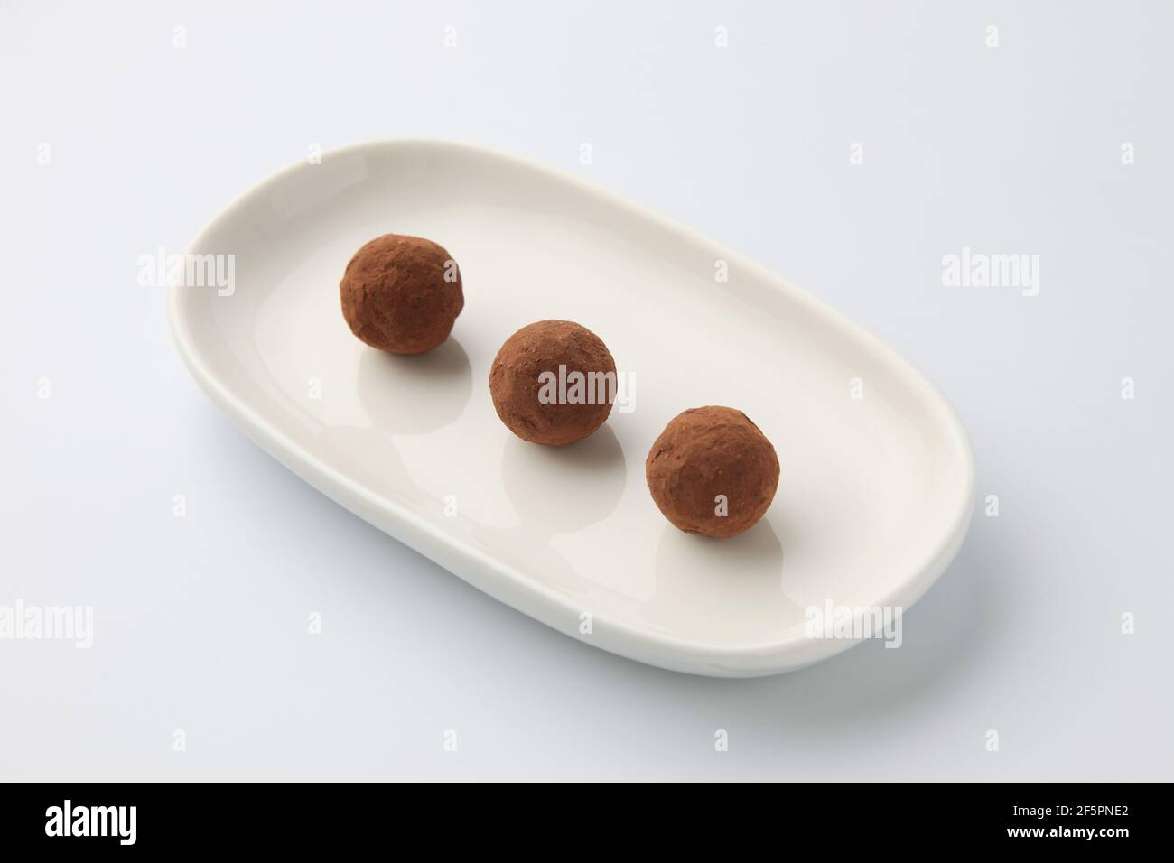 chocolate truffles on plate on white background Stock Photo - Alamy