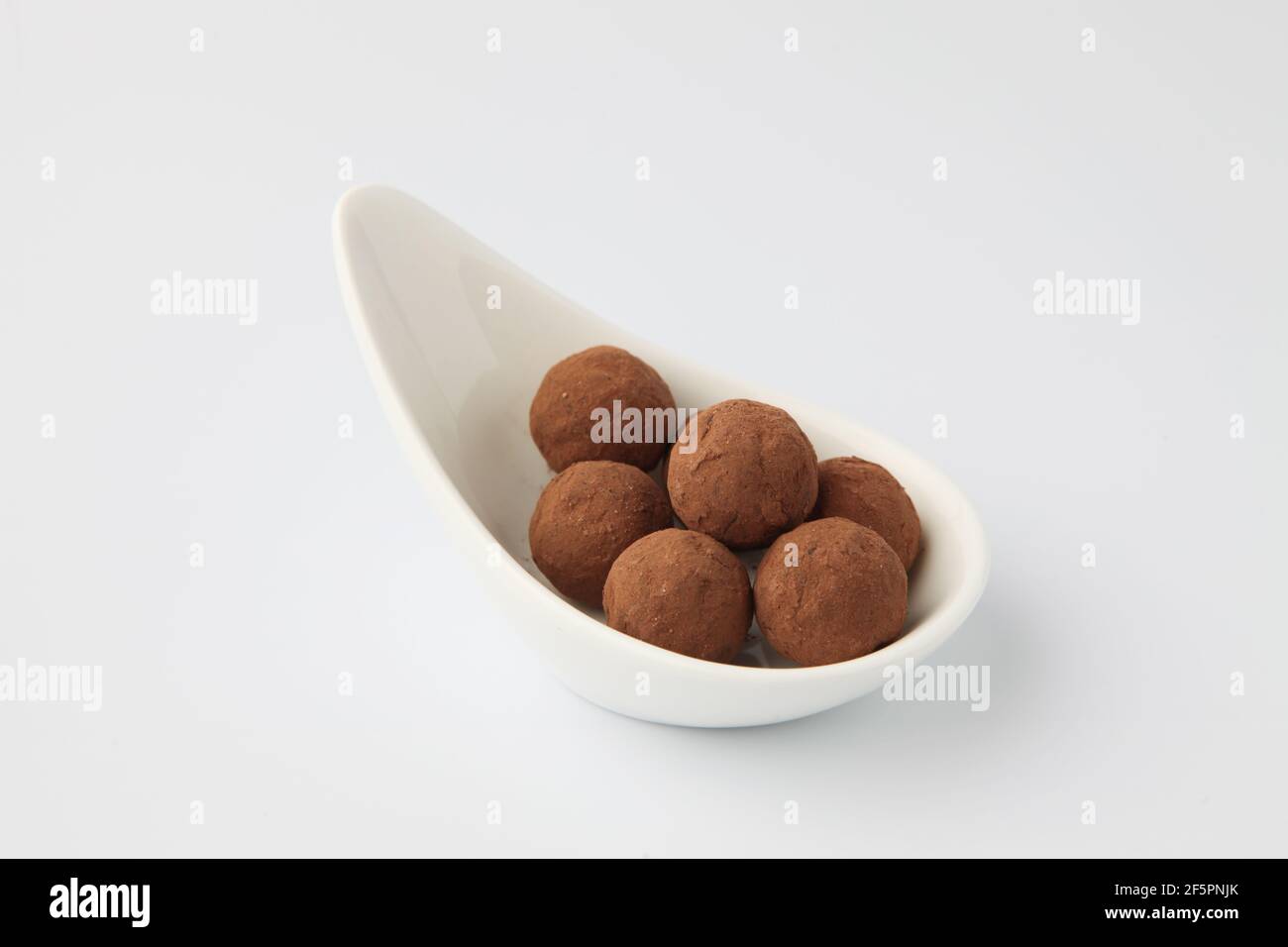 chocolate truffles on plate on white background Stock Photo - Alamy