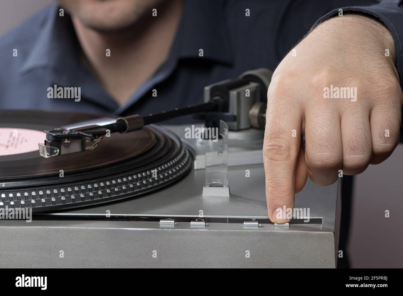 A man presses a gramophone vinyl record player button. Vintage record ...