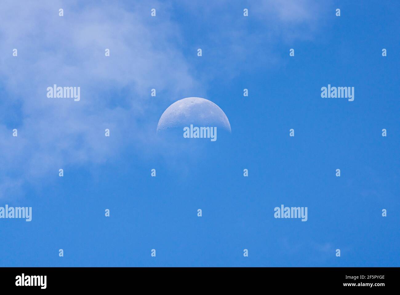 Almost cloudless blue morning-time sky with a white crescent of the ...