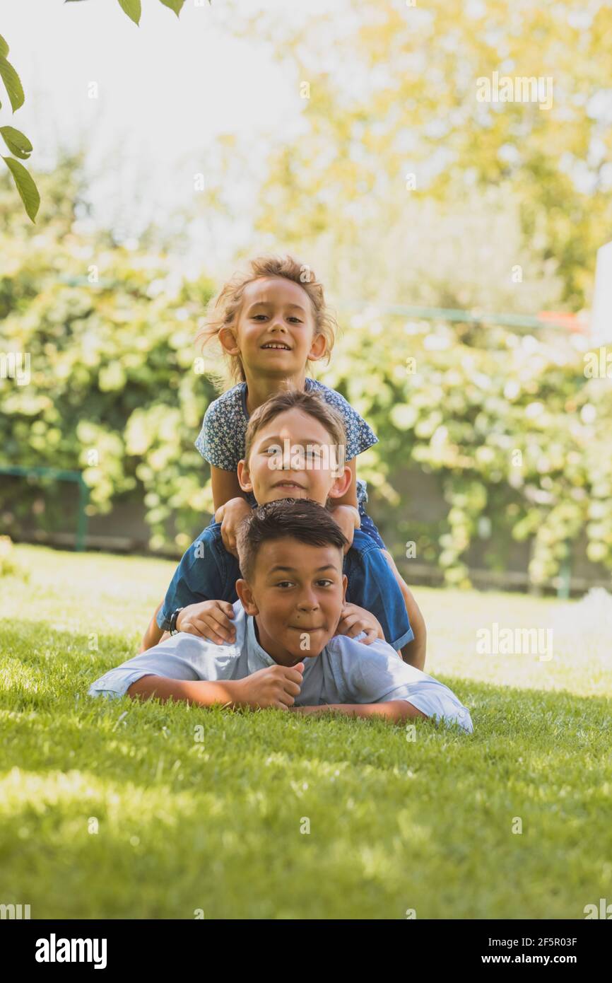 Portrait of three little children as a tower Stock Photo - Alamy