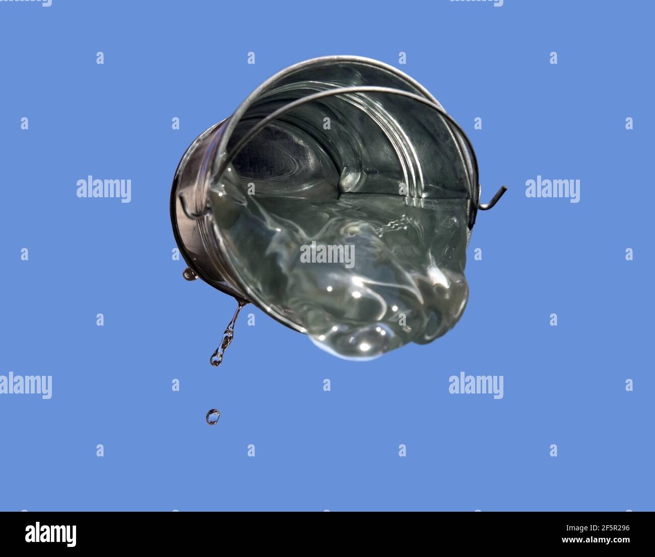 A falling buckets splashes water, on a background of blue sky Stock ...
