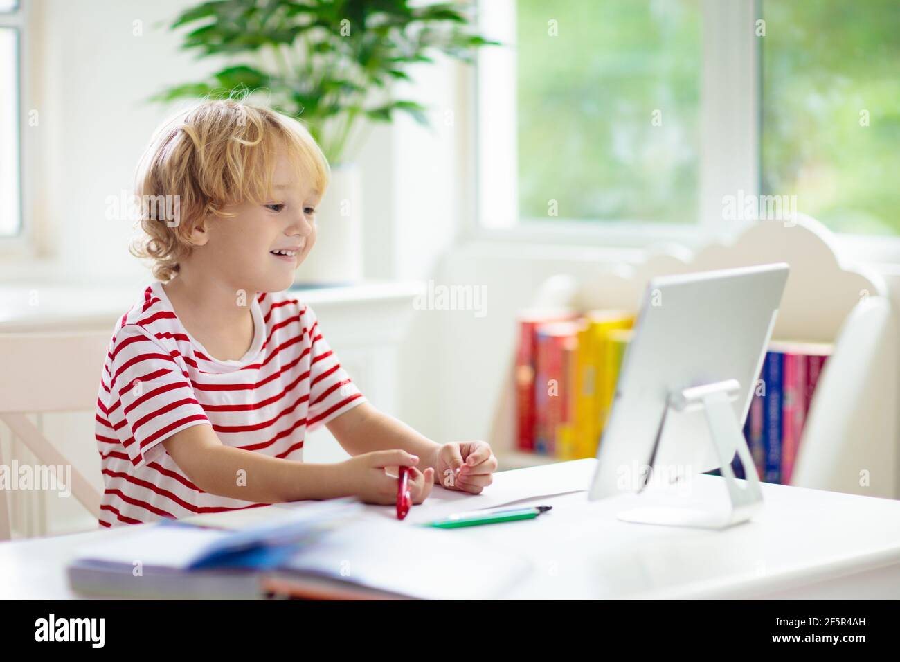 Online remote learning. School kids with computer having video ...