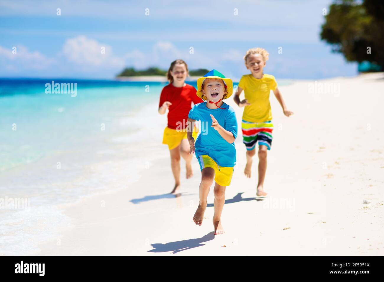 Kids playing on tropical beach. Children swim and play at sea on summer ...