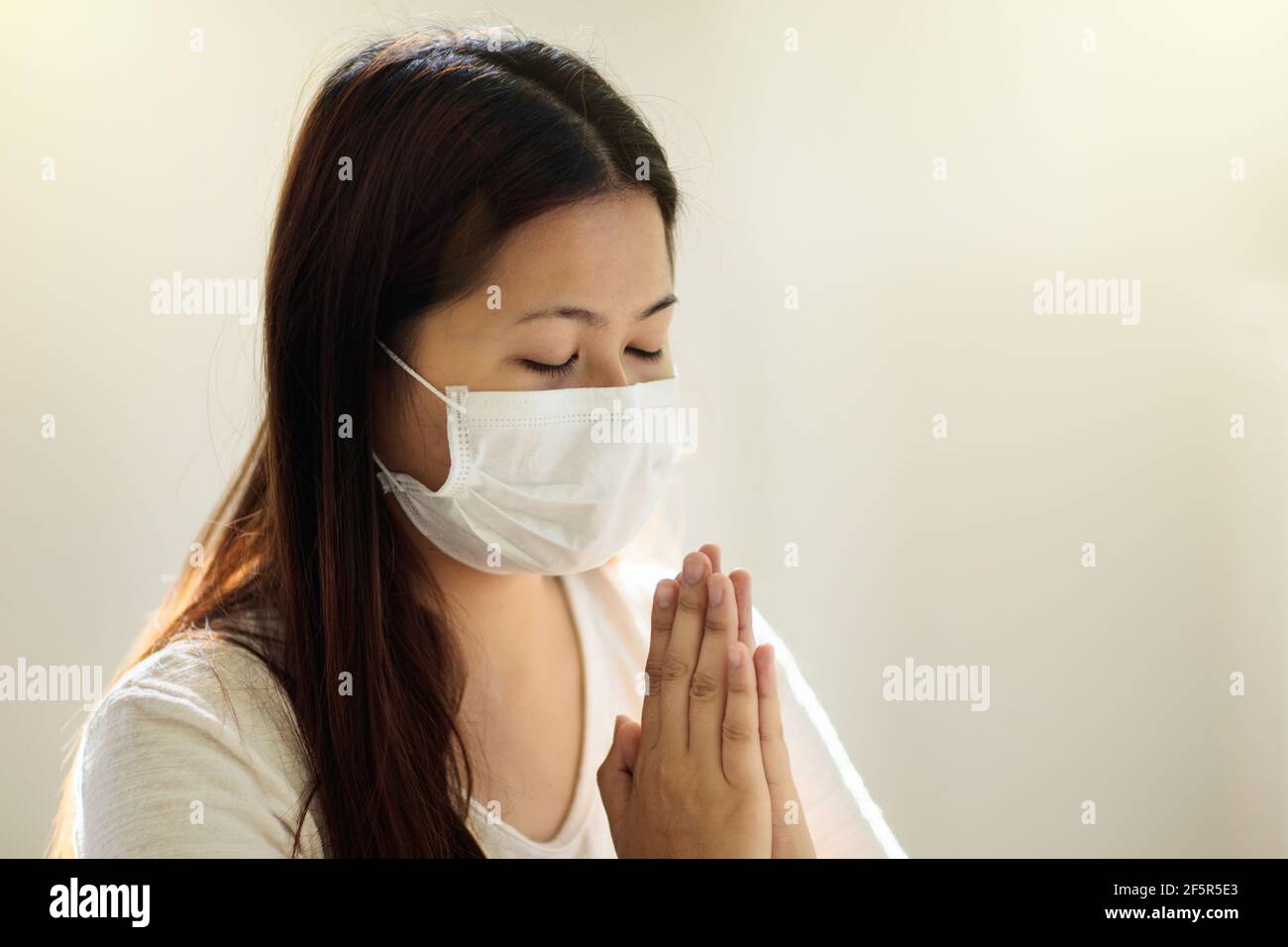 Pray for covid-19 patient. Asian woman in face mask praying for ...